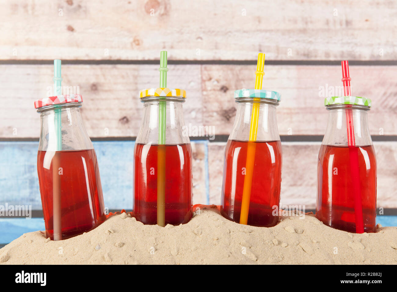 Four bottles red lemonade in sand at the beach Stock Photo - Alamy