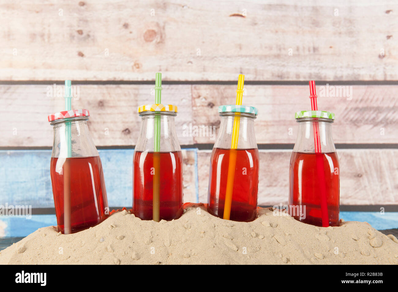 Four bottles red lemonade in sand at the beach Stock Photo - Alamy