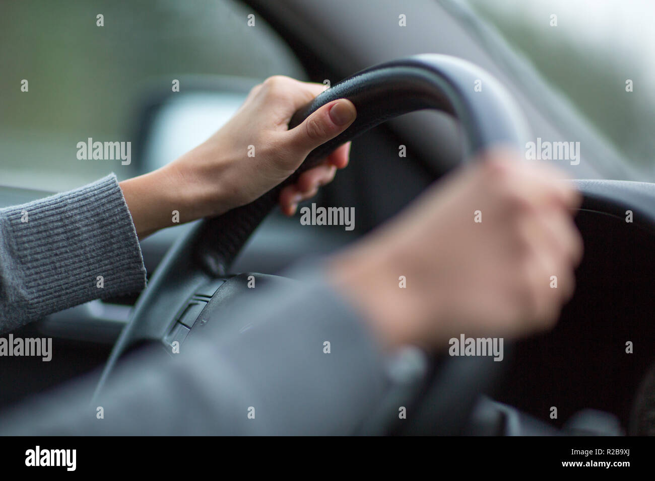 Driver's hands driving a car on a highway (color toned image; shallow ...