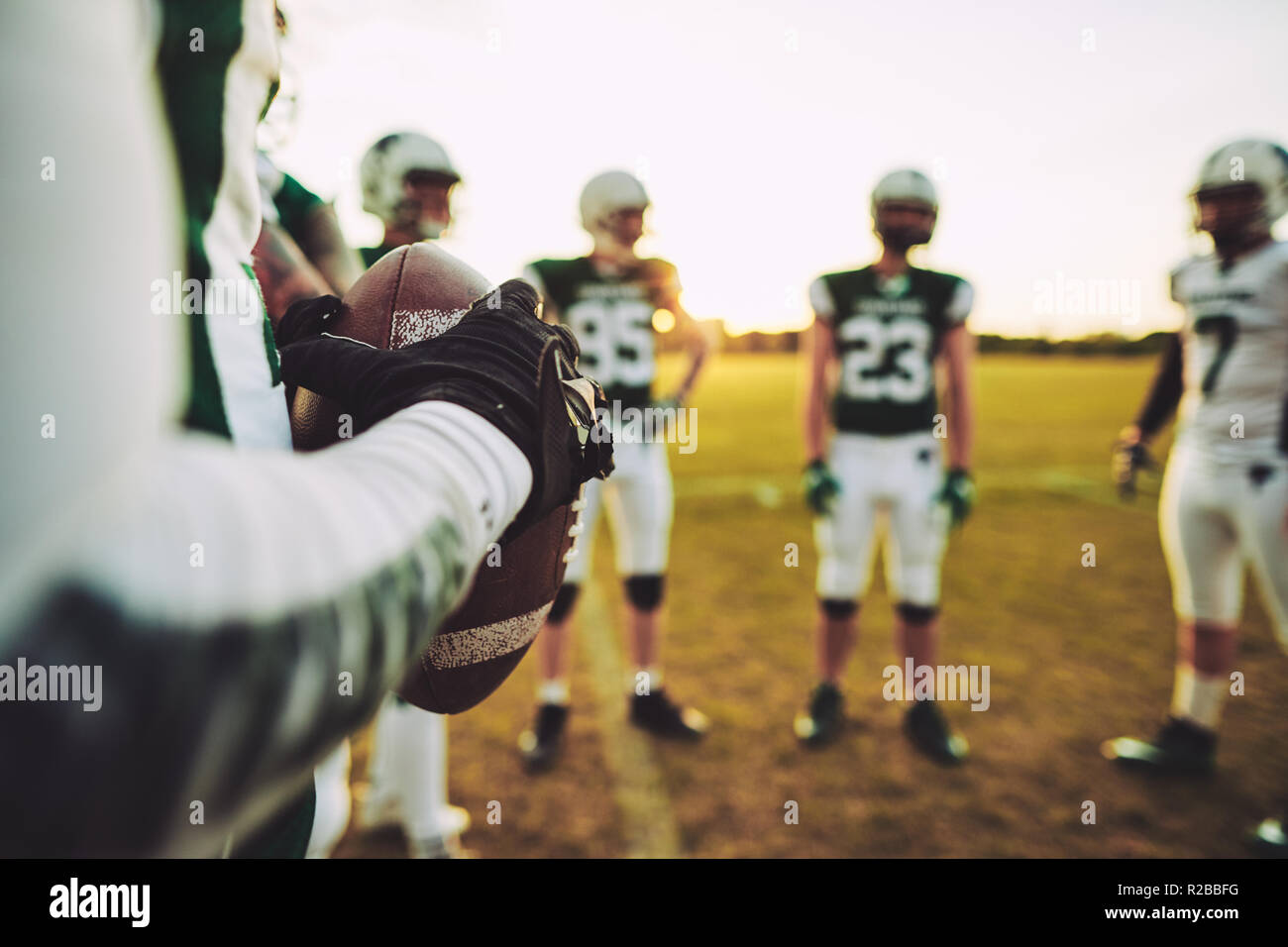 Closeup of an American football quarterback standing with his teammates ...