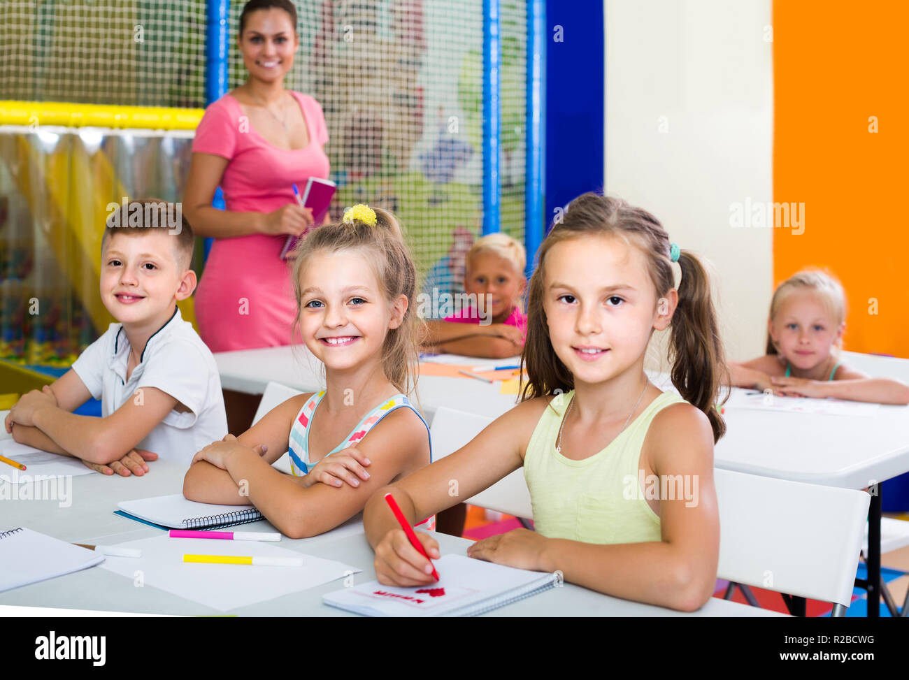 positive spanish children sitting together and studying in class at ...