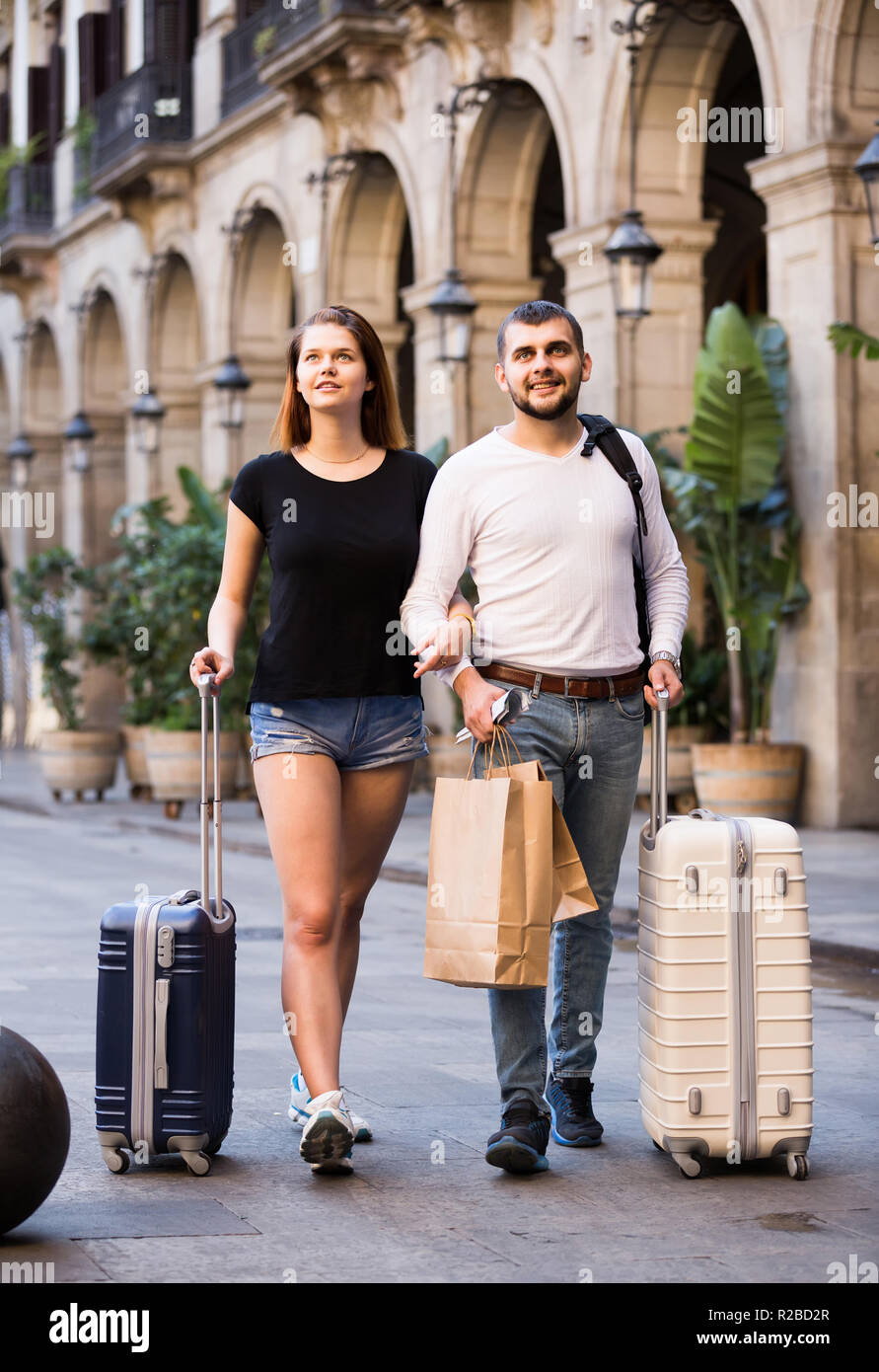 Young smiling english couple man and woman going the historic city ...