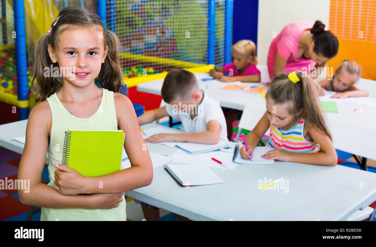Portrait of cheerful smiling pupil girl studying in school class Stock ...