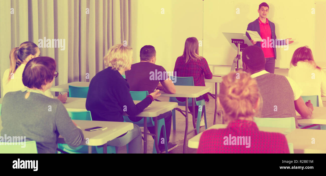 Students of different age sitting together at tables, doing group study ...