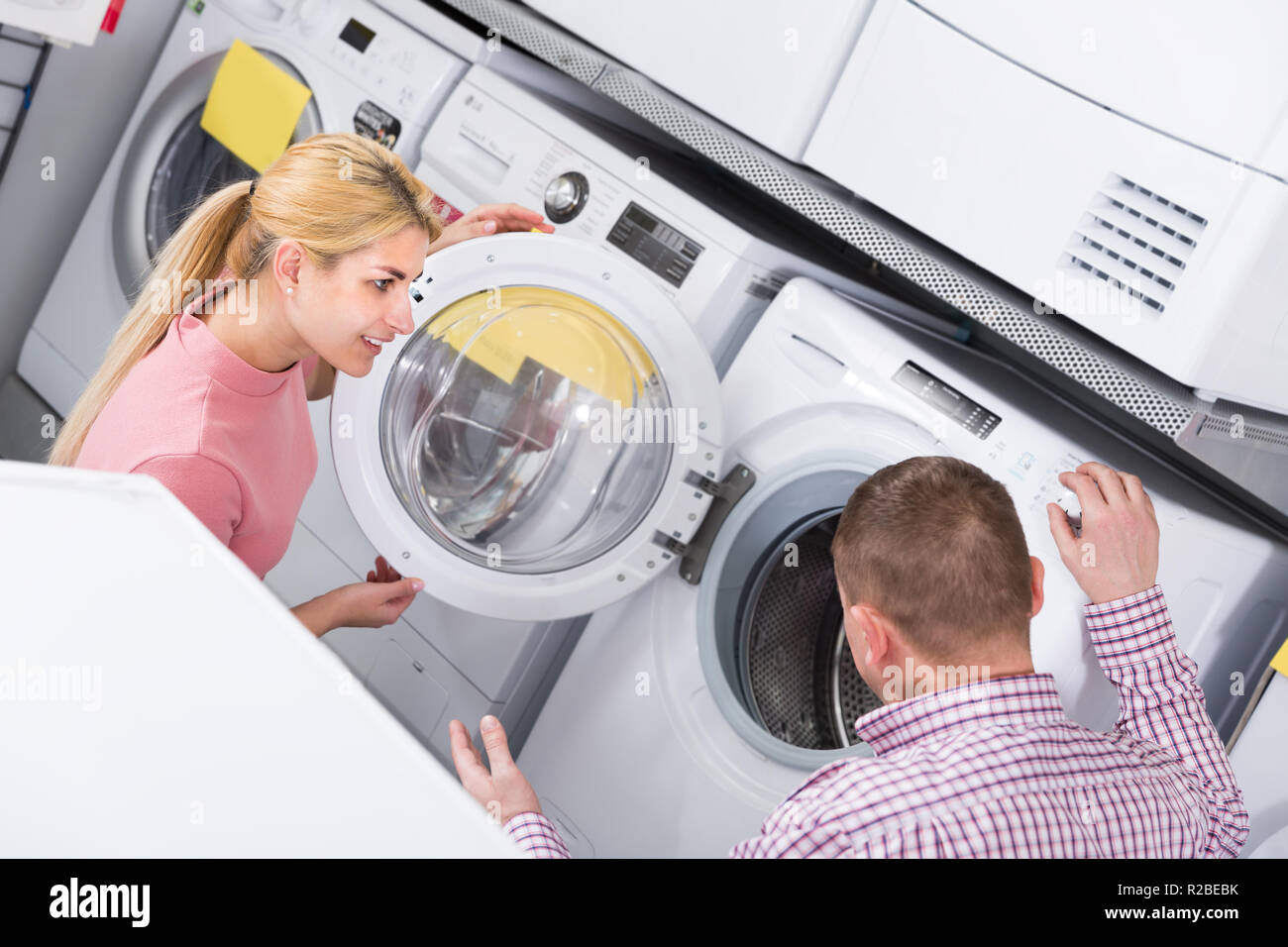Positive family chooses new washing machine in shop of household ...