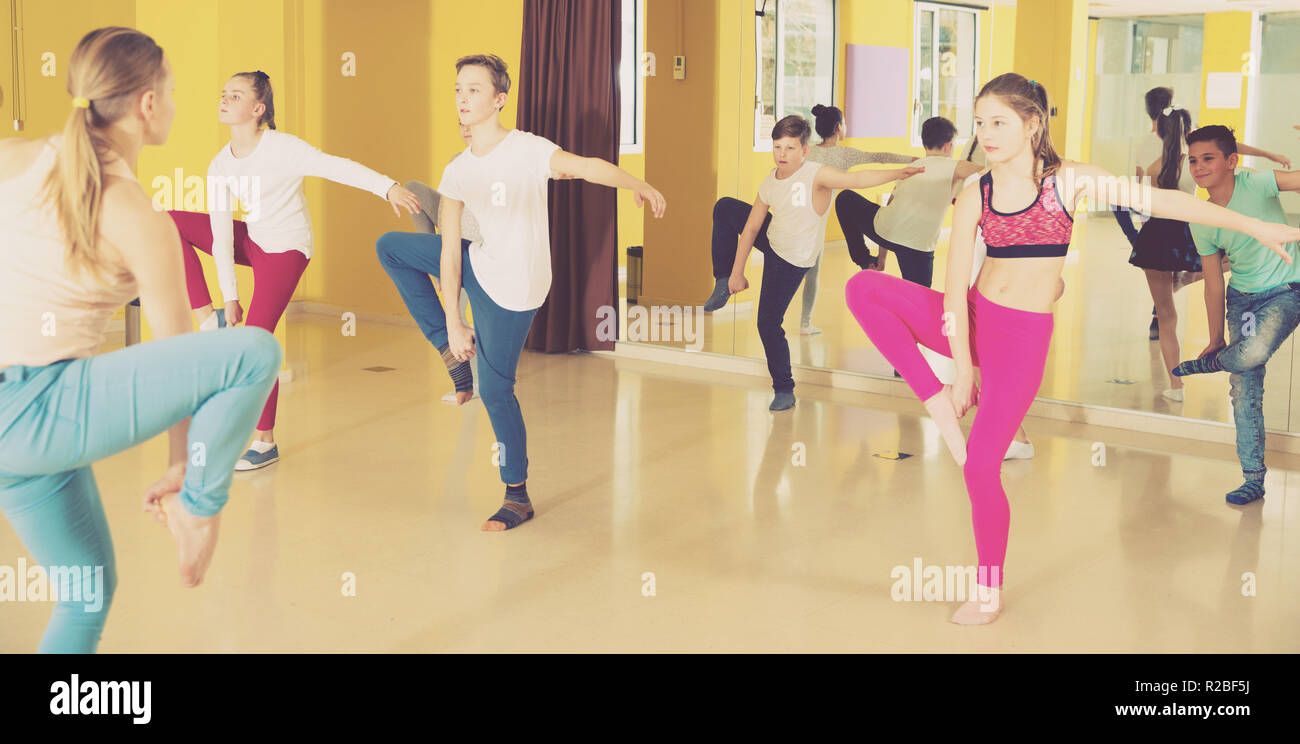 Group of children participating in dance class, following their teacher ...