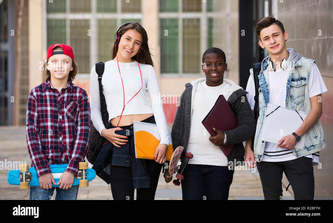 Four smiling teenage students close to university Stock Photo - Alamy