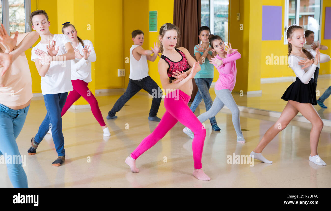 Group of children participating in dance class, following their teacher ...