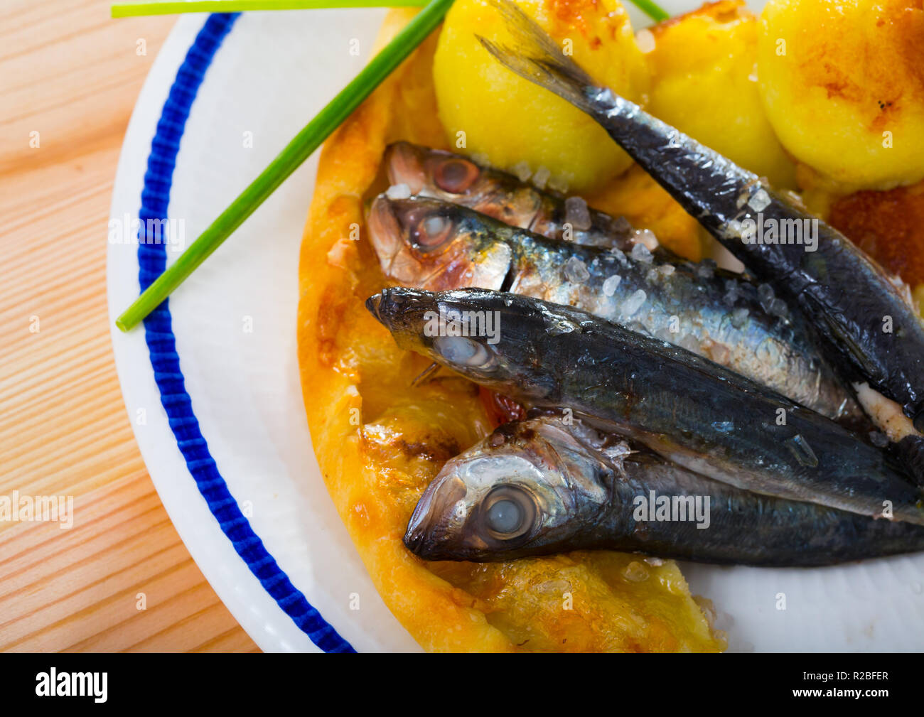 Dish of tasty fried anchovy with potato croquettes and cake served on ...