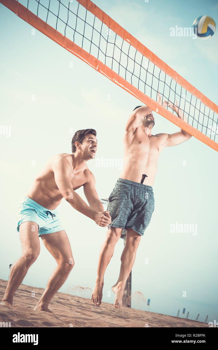 Two friends are playing in volleyball on the beach Stock Photo - Alamy
