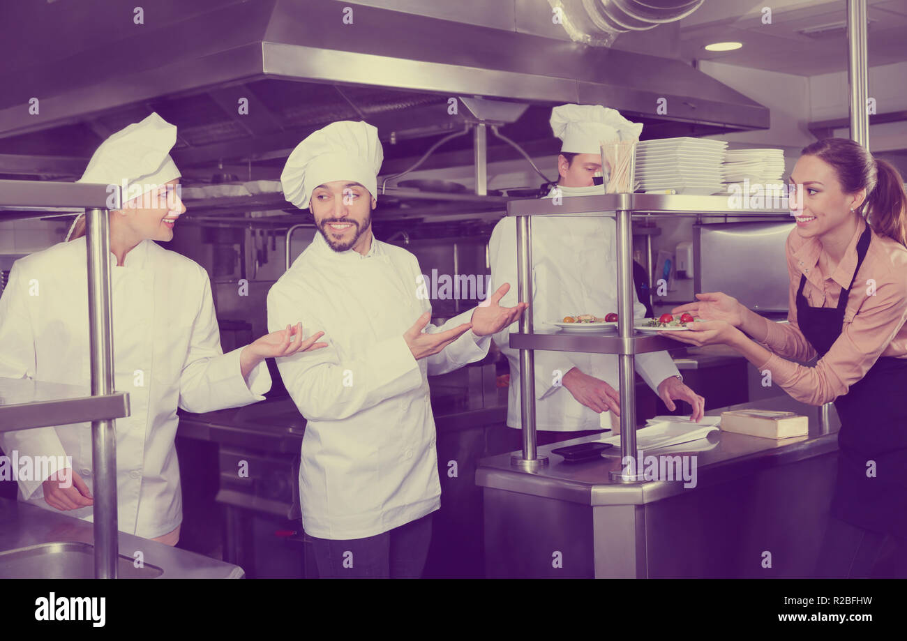 Head chef checking dishes in a kitchen of restaurant before serving ...