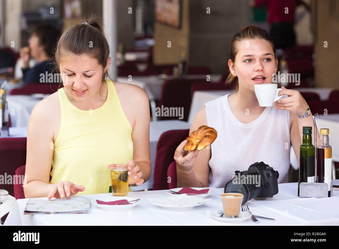 portrait of two happy british female friends searching route on the map ...
