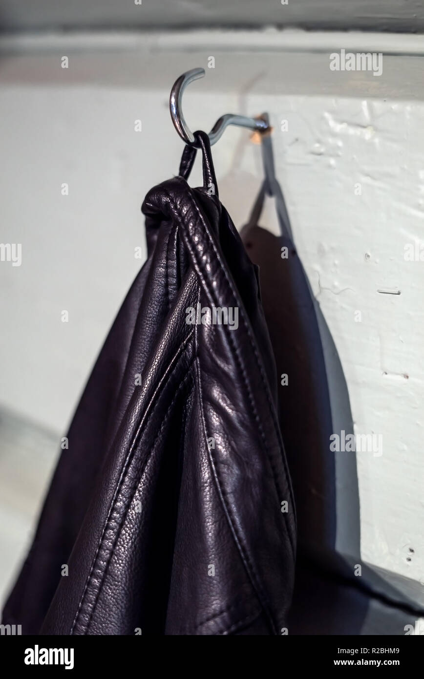 An unformal, hip black leather male jacket hanging from a robust ...