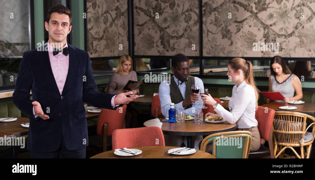 Polite confident waiter inviting to visit modern urban restaurant Stock ...