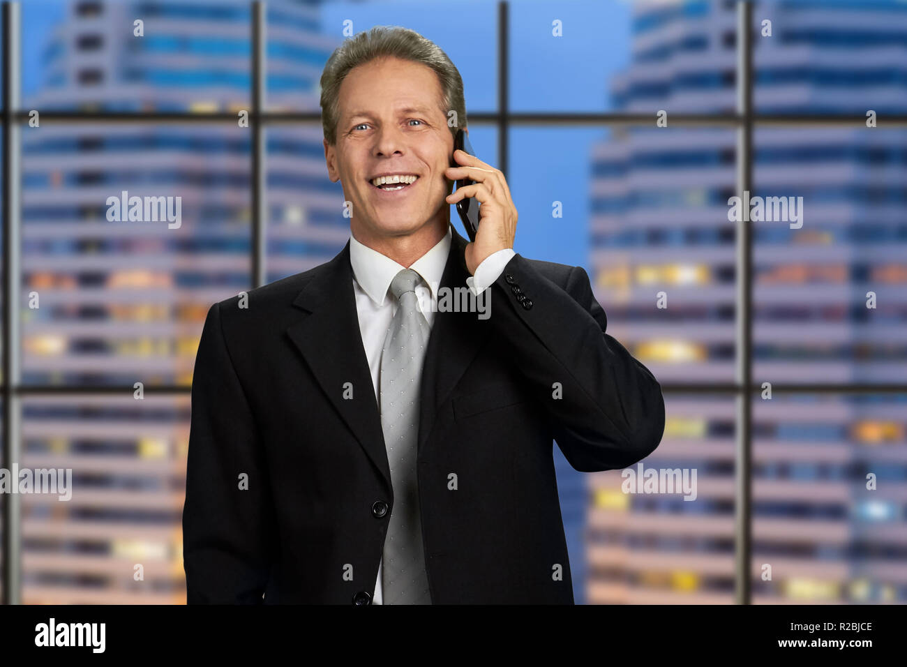 Happy businessman talking on phone. Mature man in formal wear talking ...