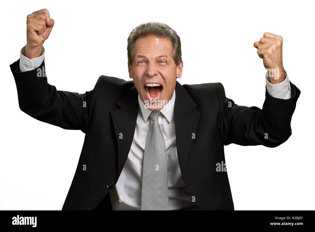 Successful excited businessman raising his fists. Ecstatic triumphant ...