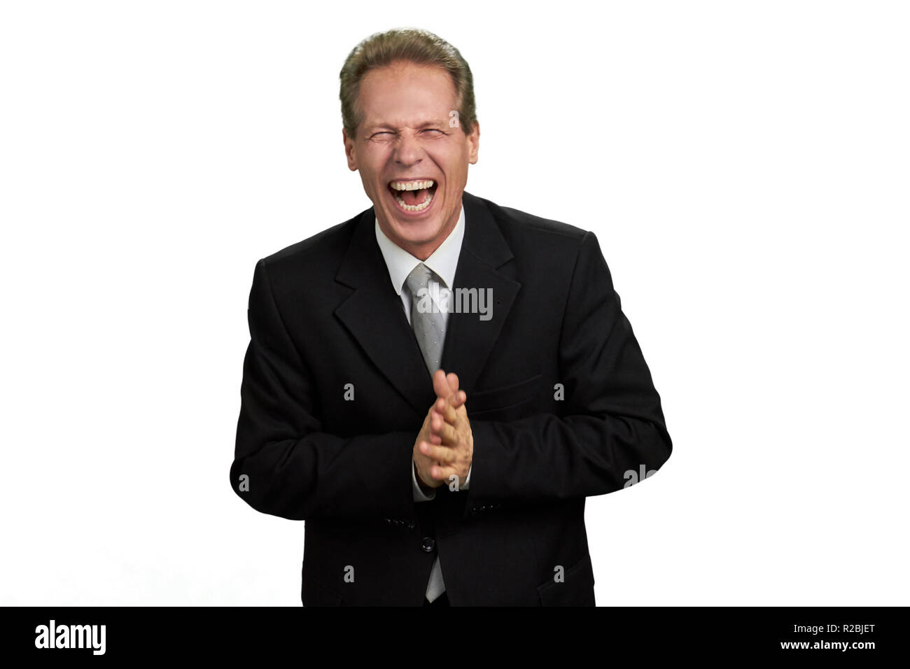 Handsome businessman bursting into laughing. Laughing male executive ...