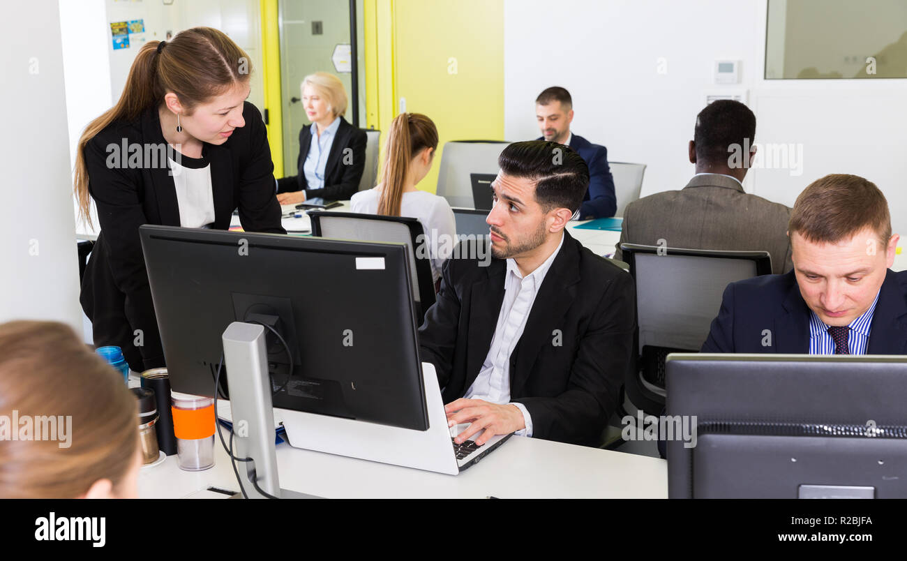 Successful coworkers engaged in business activities in busy open plan ...
