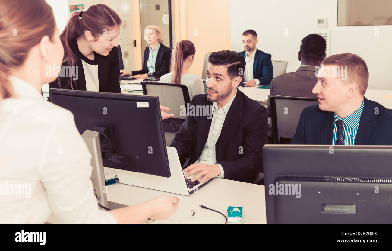 Successful coworkers engaged in business activities in busy open plan ...