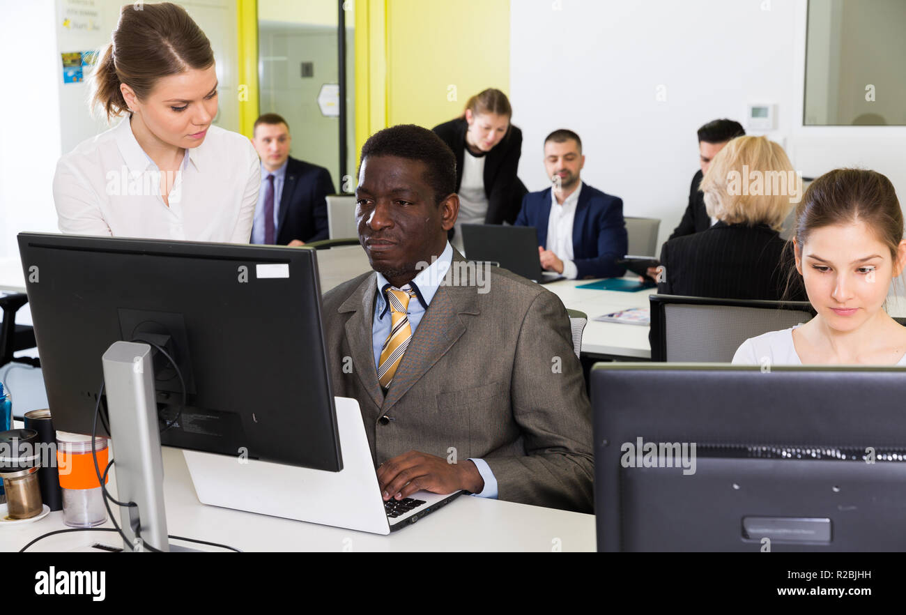 Successful coworkers engaged in business activities in busy open plan ...