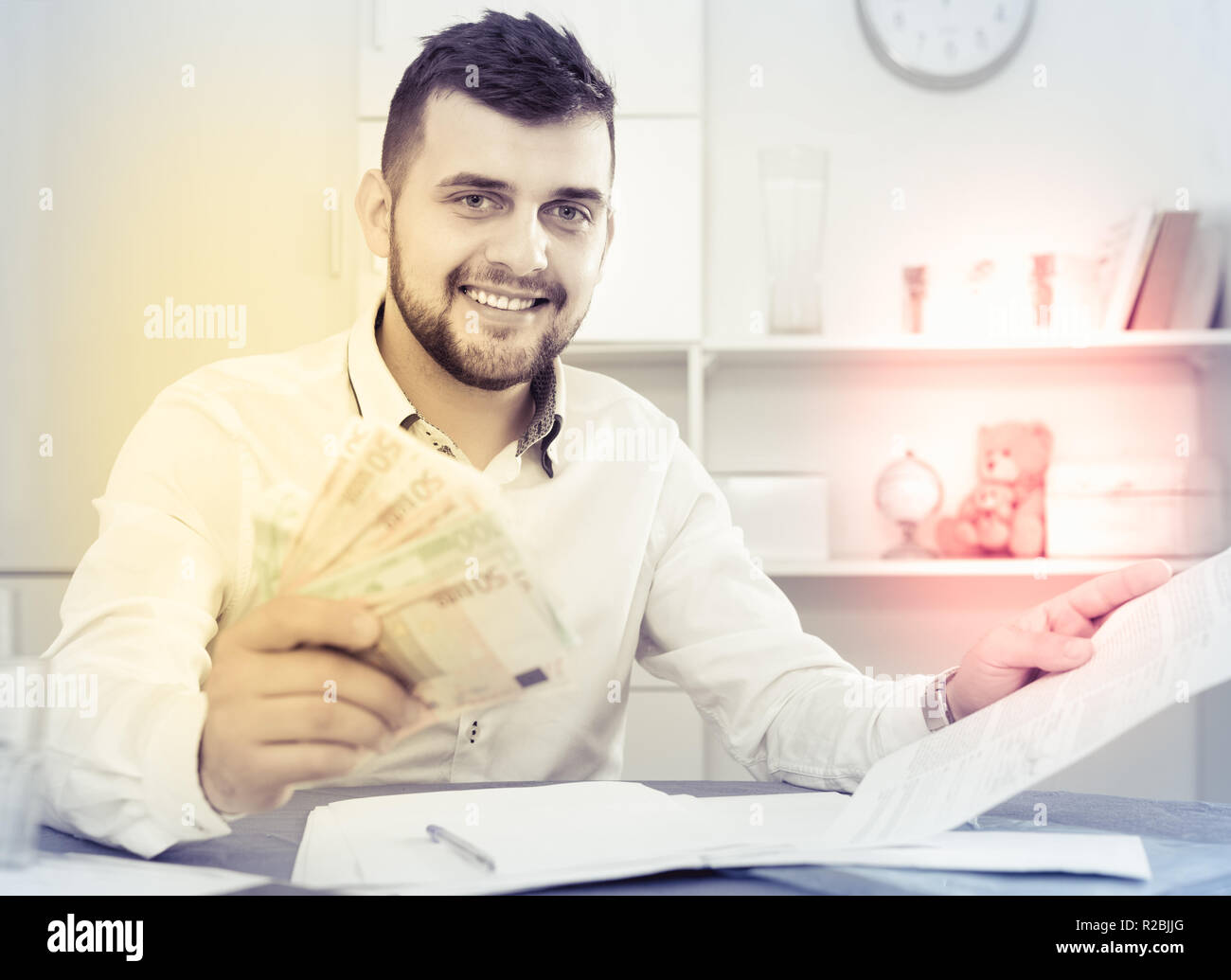 Young happy cheerful positive man struggling to pay utility bills and ...