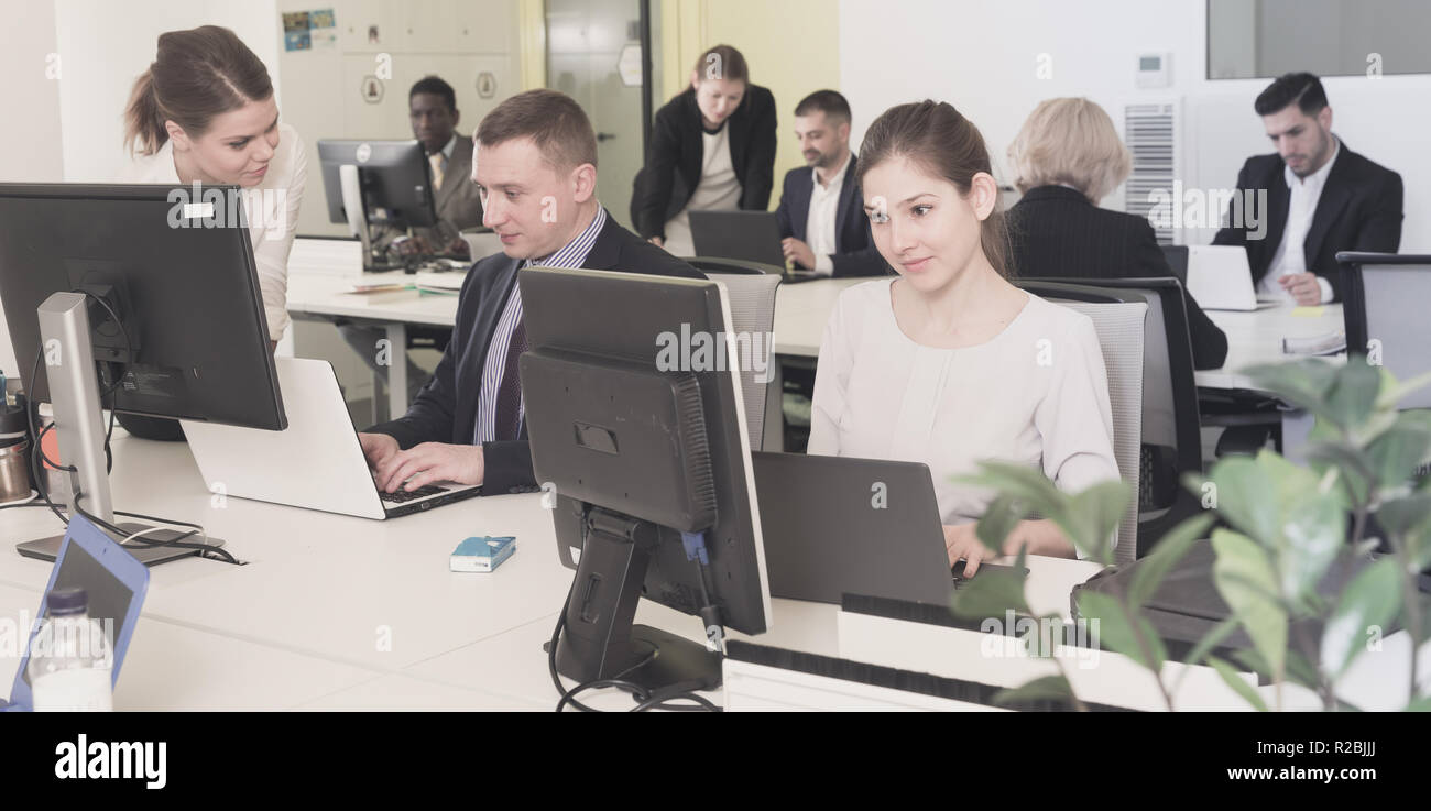 Successful coworkers engaged in business activities in busy open plan ...