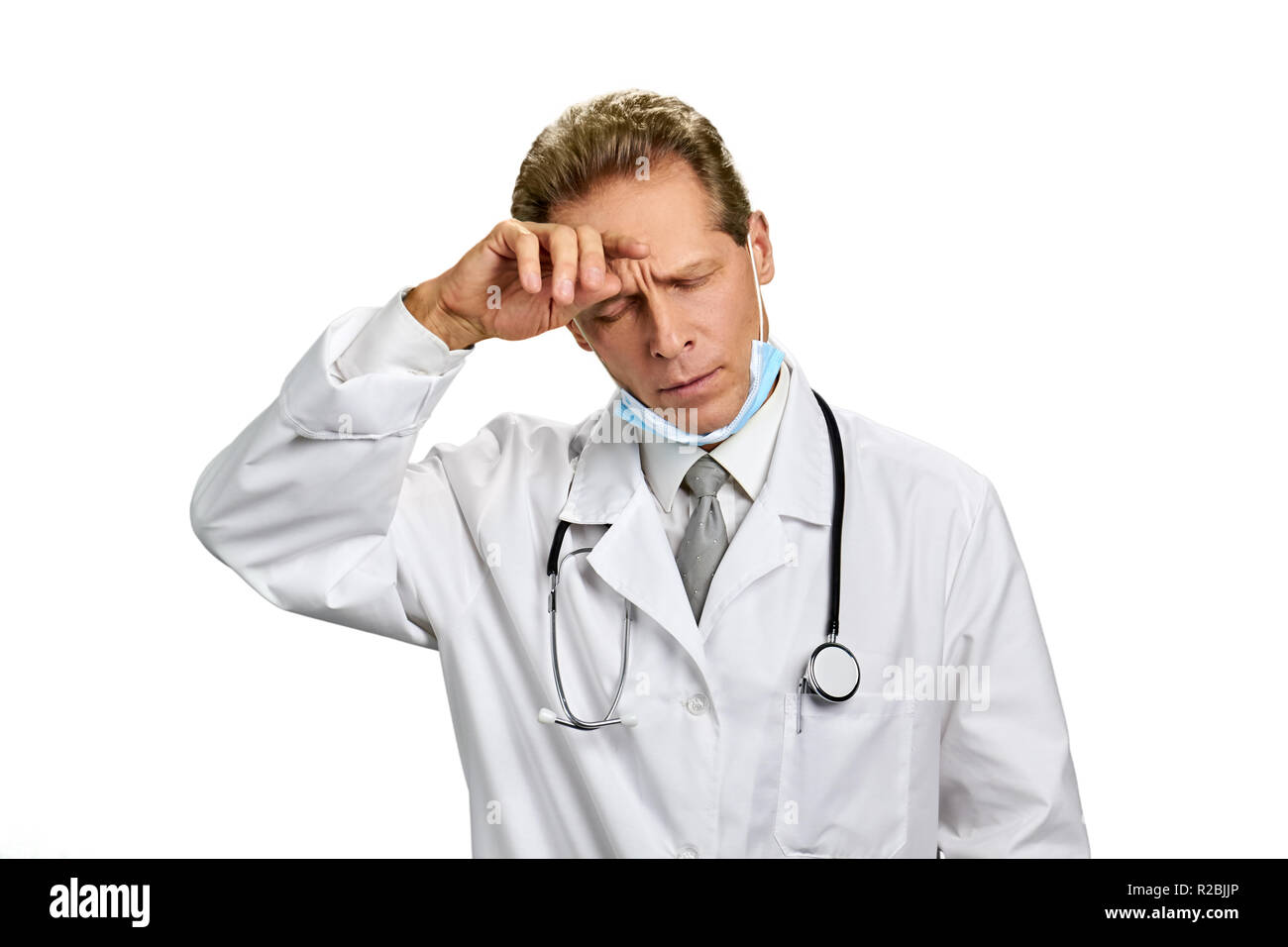 Portrait of tired doctor on white background. Depressed mature doctor ...