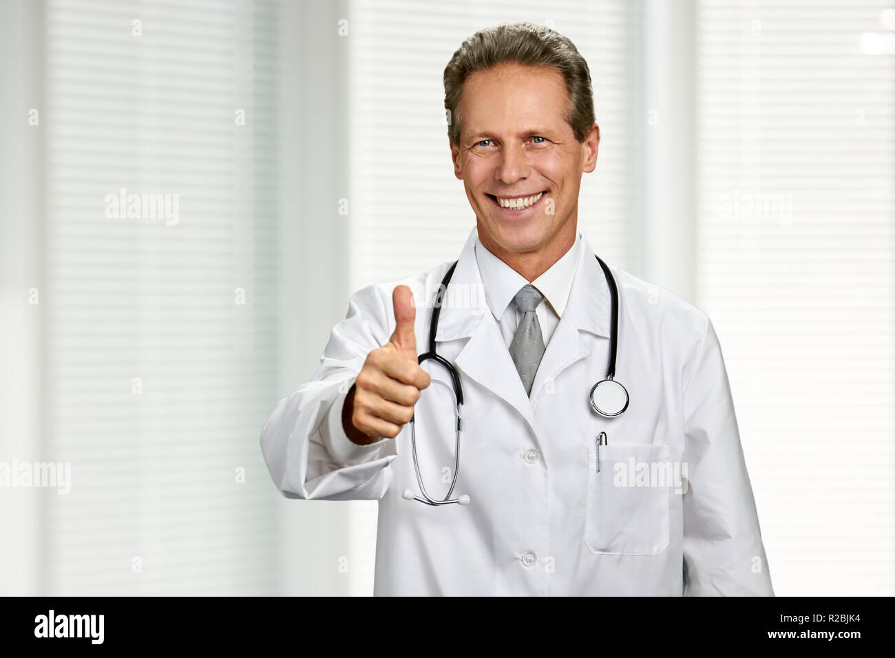 Happy physician showing thumb up. Mature doctor man in white coat ...