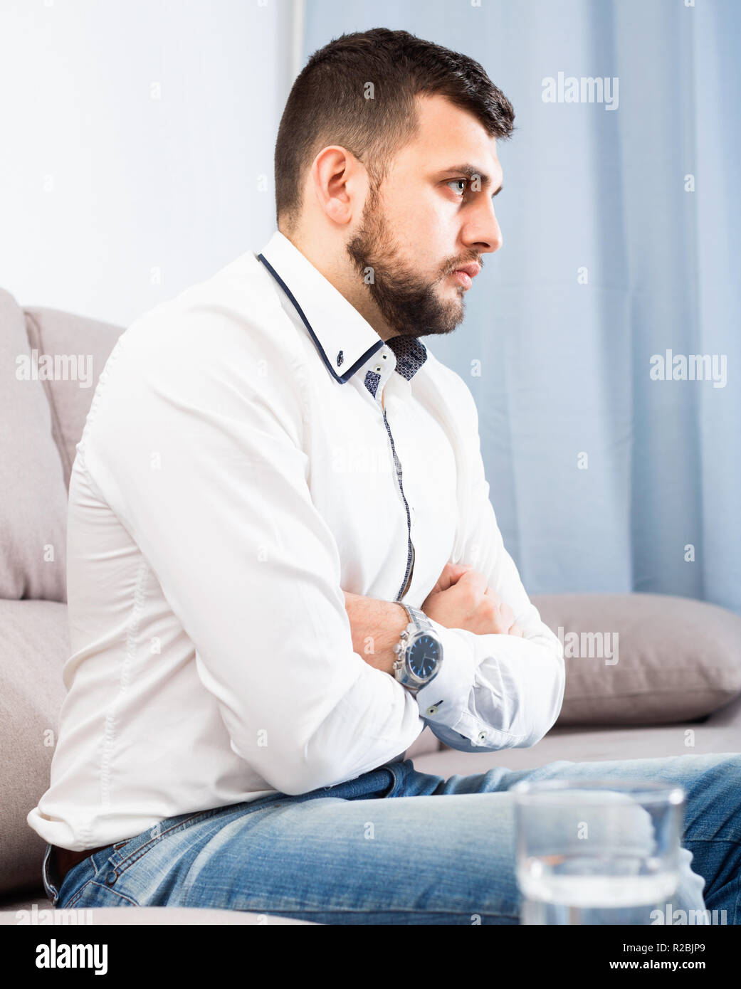 Young sad man feeling distressed and lonely alone at home Stock Photo ...