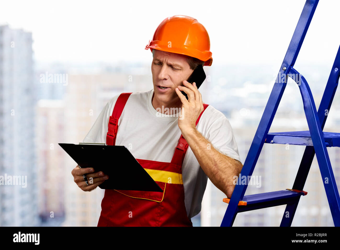 Construction worker talking on smartphone. Construction engineer ...