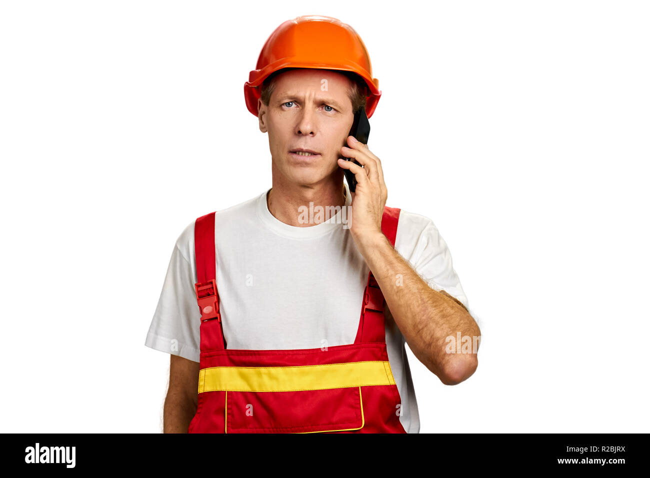 Portrait of builder talking on phone. Angry construction engineer ...