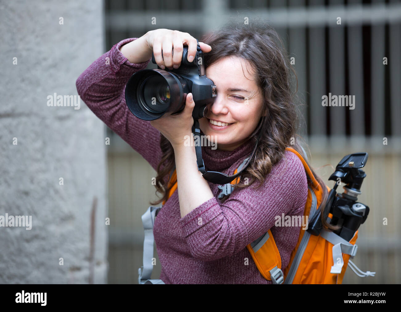 smiling girl photographer holding camera in hands and photographing in ...