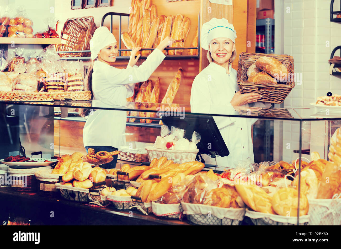 Portrait of friendly happy women at a bakery display with a pastry ...