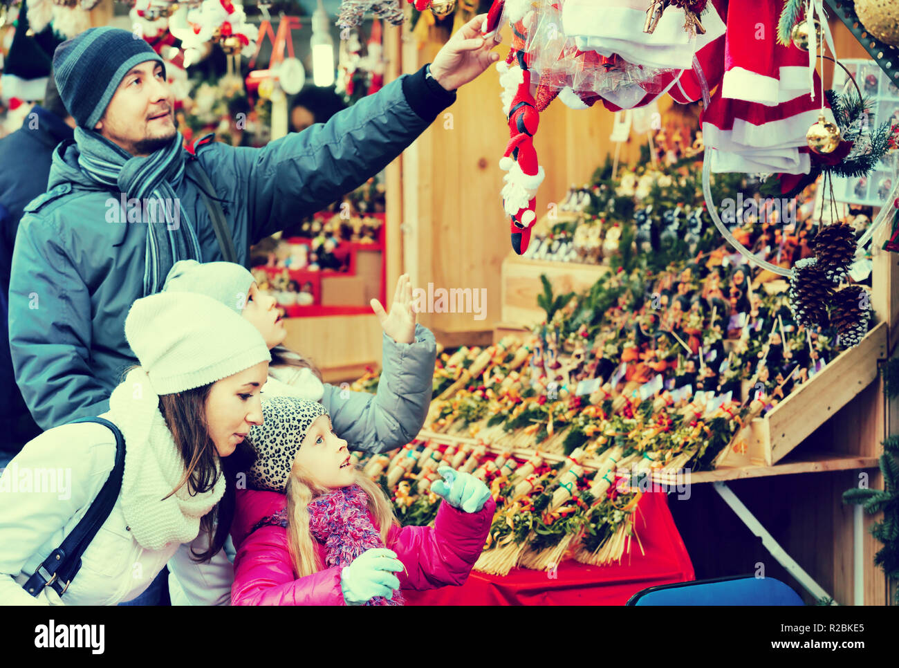Ordinary family with little girls standing at the coniferous Christmas ...