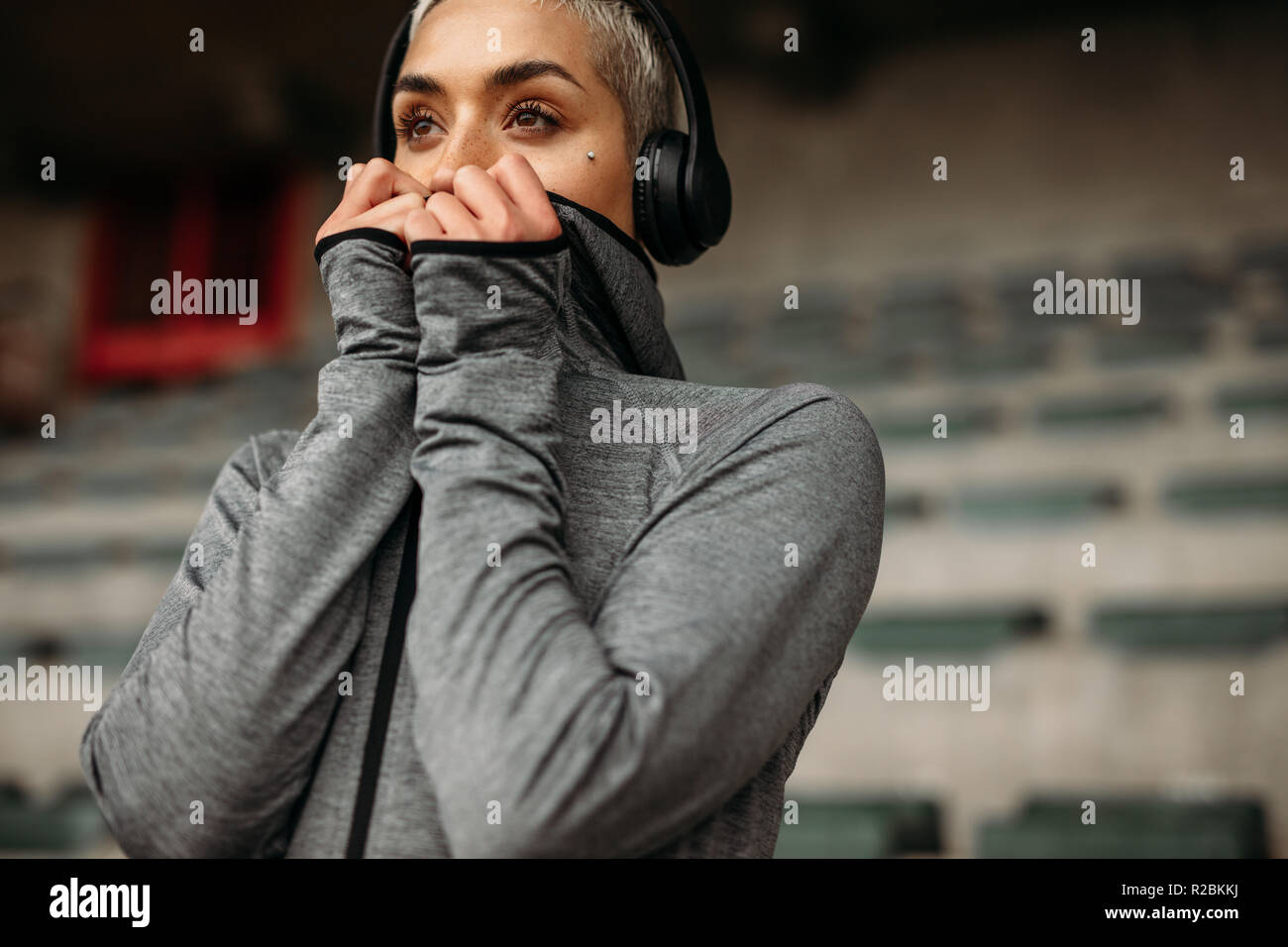fitness woman relaxing after workout listening to music on headphones ...