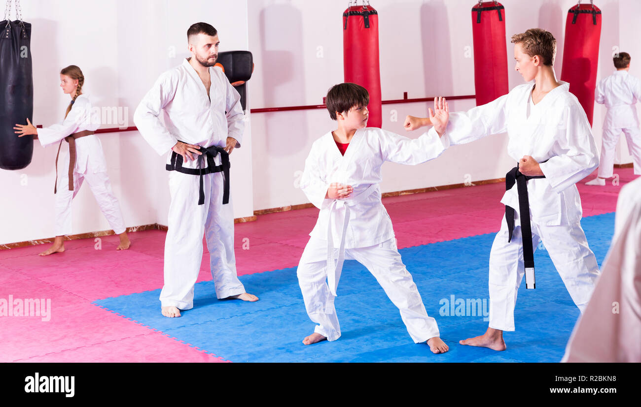 serious young children working in pair mastering new karate moves ...