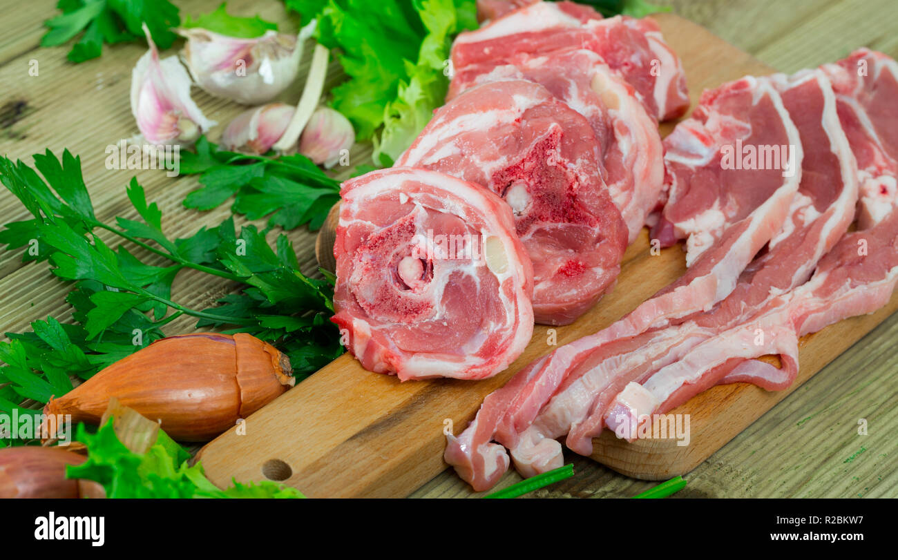 Fresh slices of mutton and vegetables assortment on natural wooden desk ...