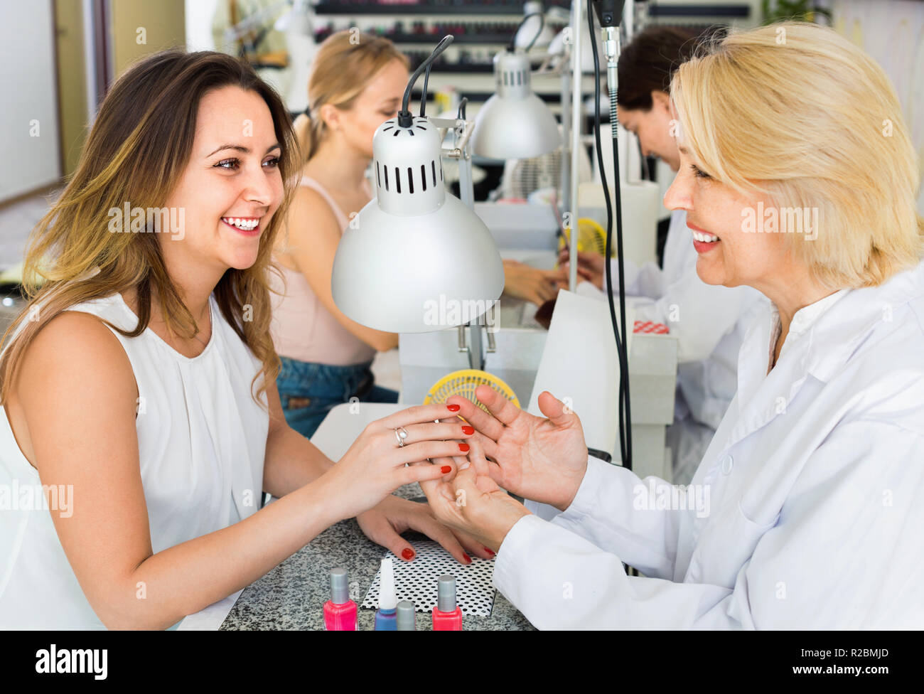 Two happy women clients having manicure done in nail salon Stock Photo ...