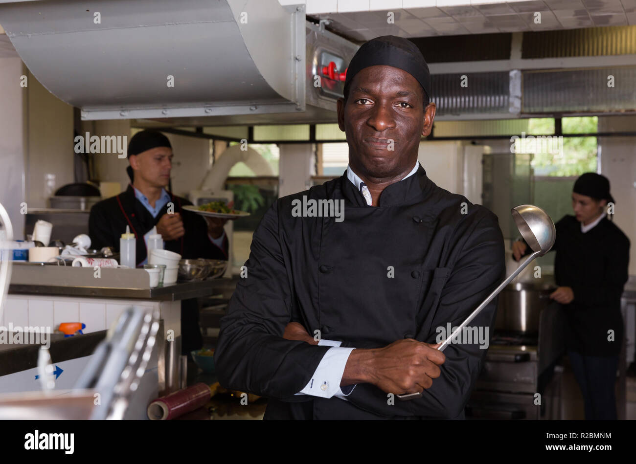 Experienced professional African-American chef standing in kitchen of ...