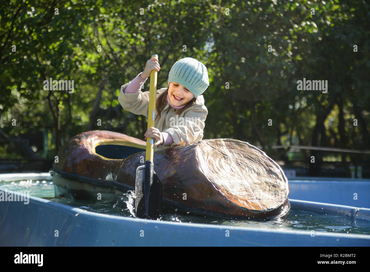 Happy girl goes boating in amusement park Stock Photo - Alamy