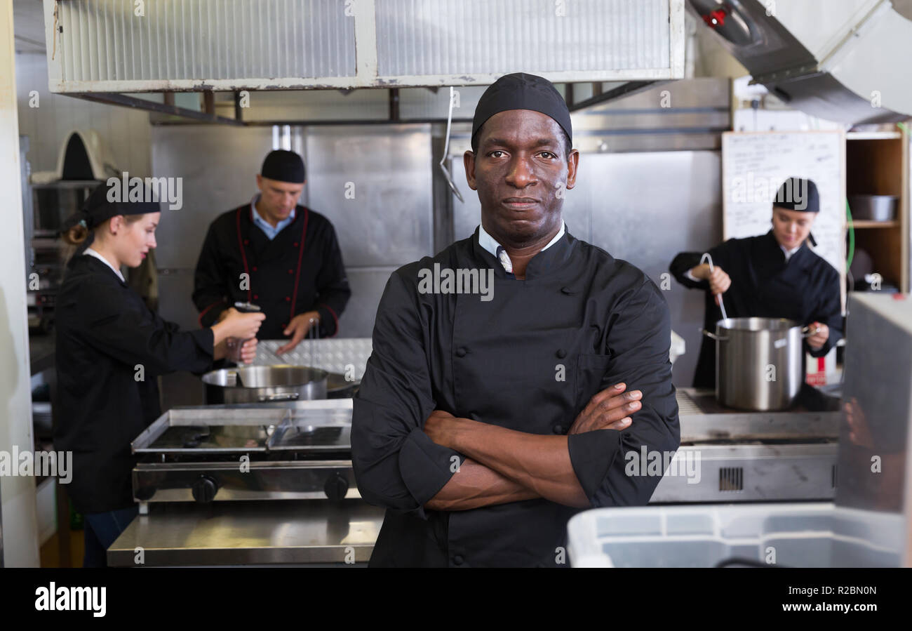 Portrait of confident African American chef in restaurant kitchen with ...