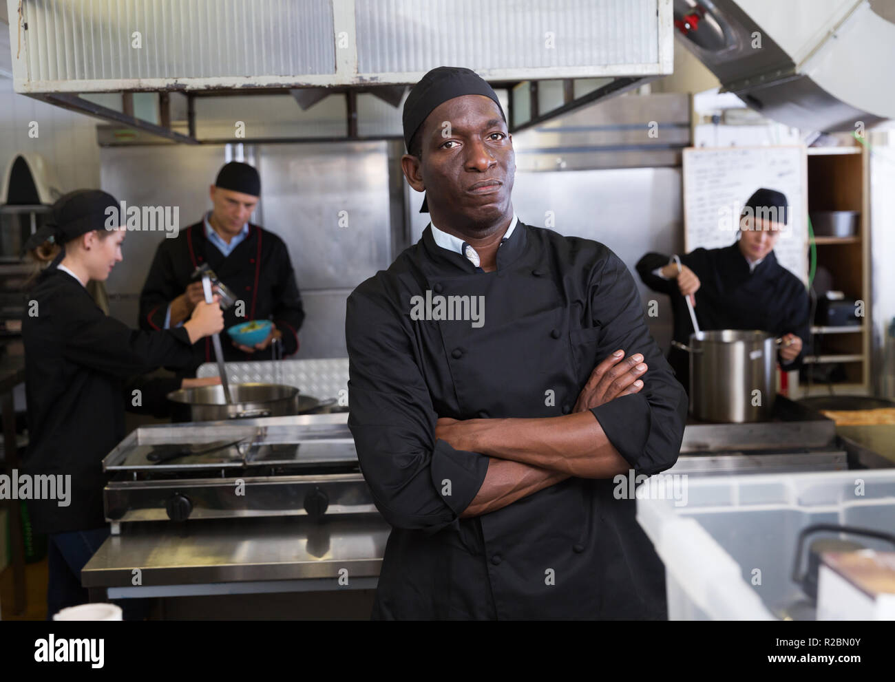 Experienced professional African-American chef standing in kitchen of ...