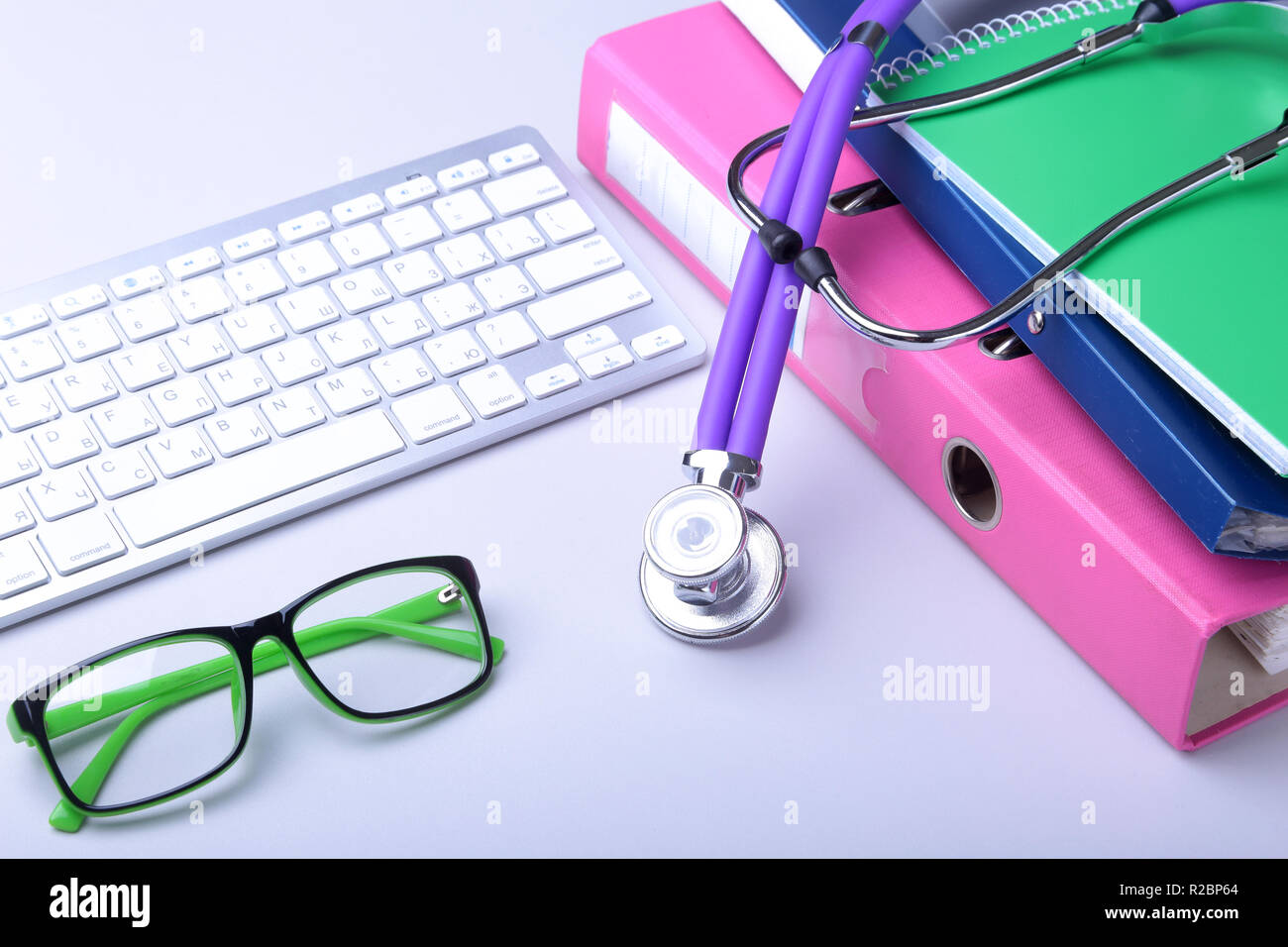 Medical record concept with stethoscope over pile of folders. Keyboard ...