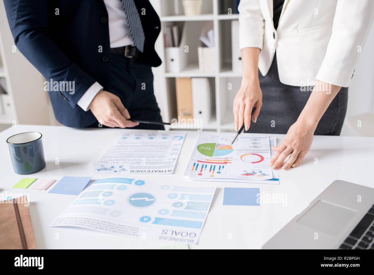 Business experts analyzing diagram together Stock Photo - Alamy