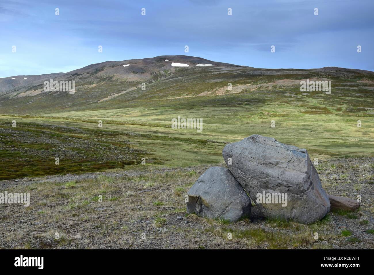 Icelandic landscape. A hill with a couple of rocks in front on ...