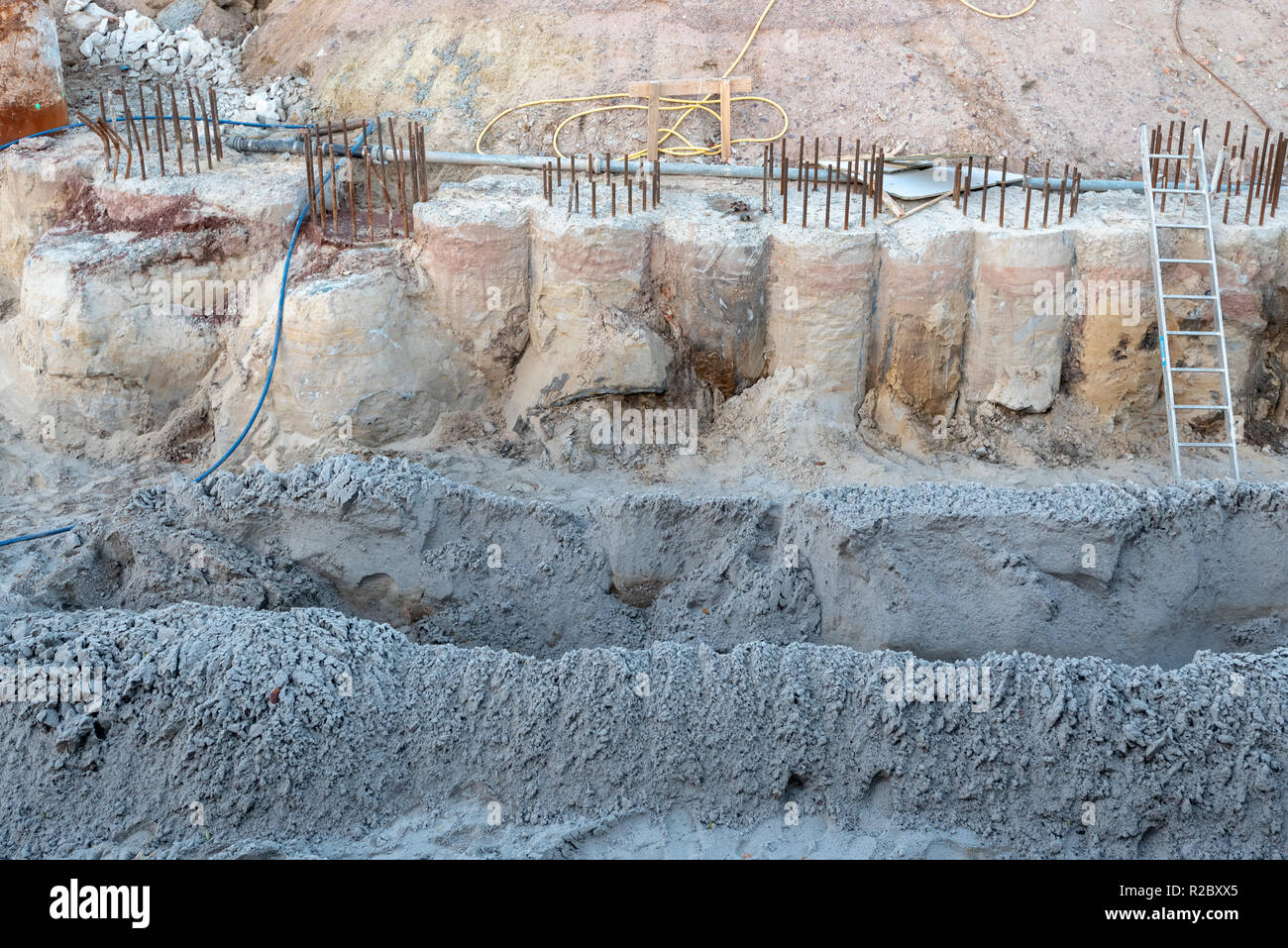 View of a pit and concrete pile with a ladder on a construction site ...