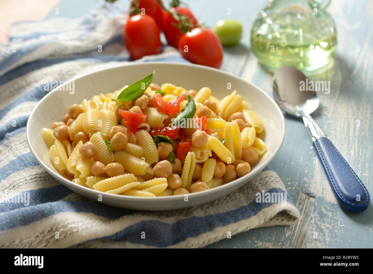 Italian gnocchi pasta with tomatoes, basil and chickpeas - closeup ...