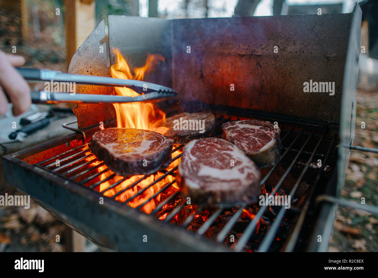 photo of raw ribeye-steaks getting grilled with high flame Stock Photo ...