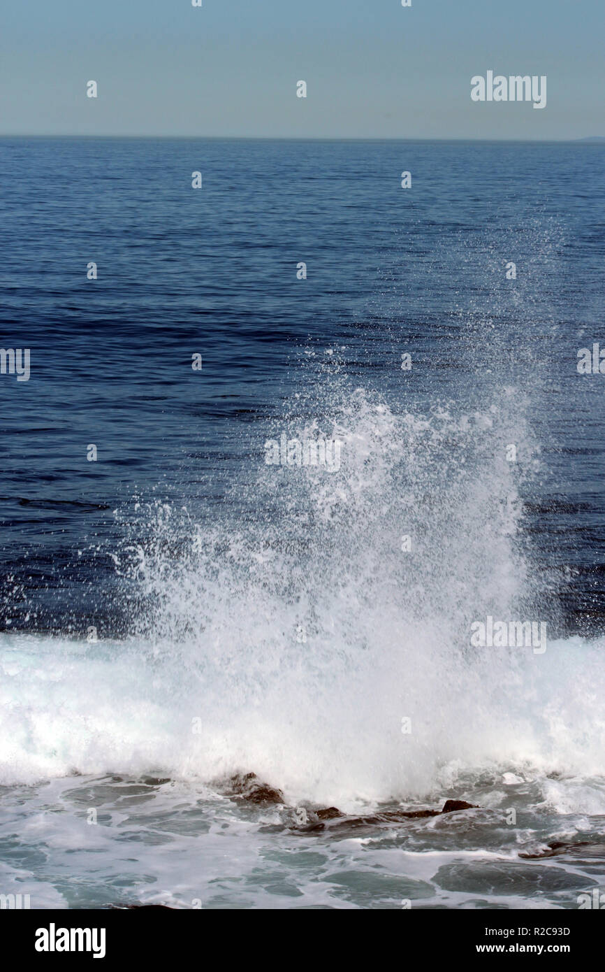 Water spray from wave crashing into rocks in the Pacific Ocean Stock ...