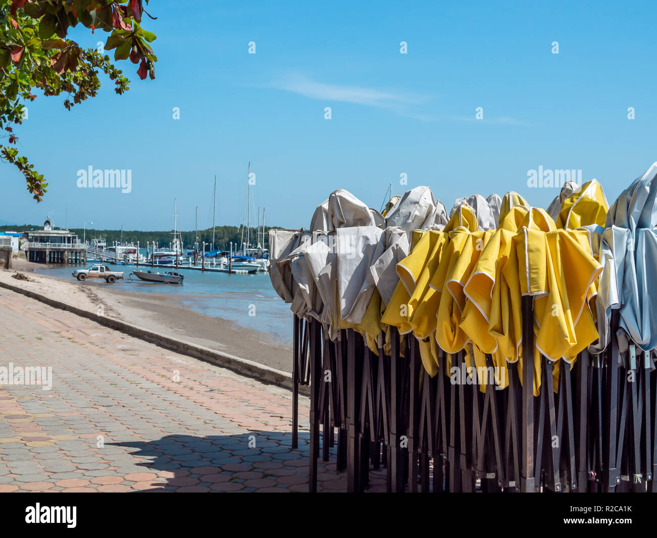 Old white and yellow outdoor folding tent standing on footpath hexagon ...